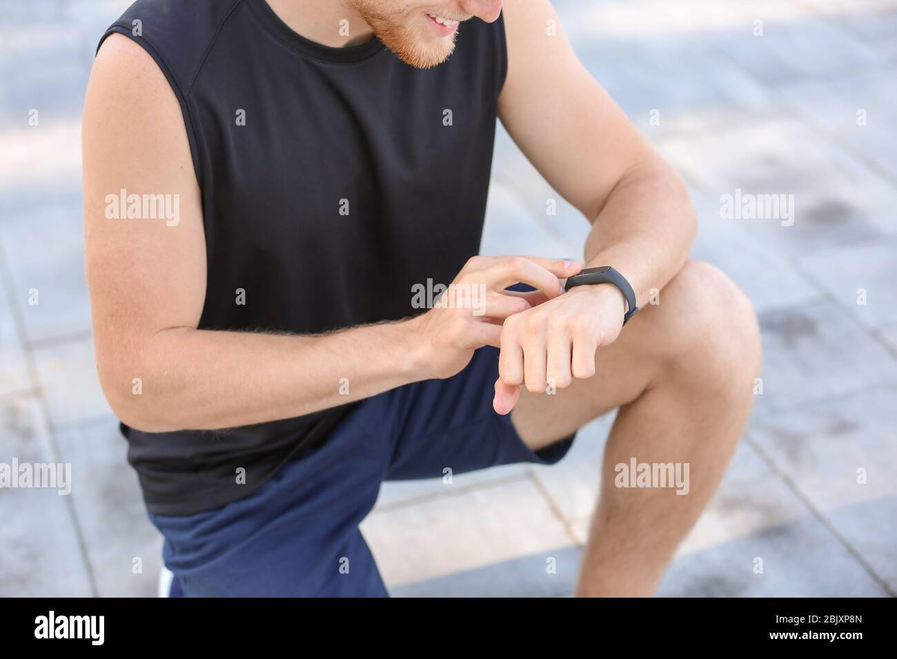 Sporty young man checking his pulse outdoors Stock Photo - Alamy