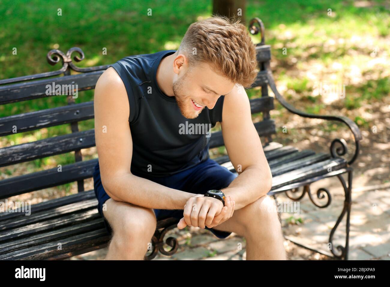 Sporty young man checking his pulse outdoors Stock Photo - Alamy