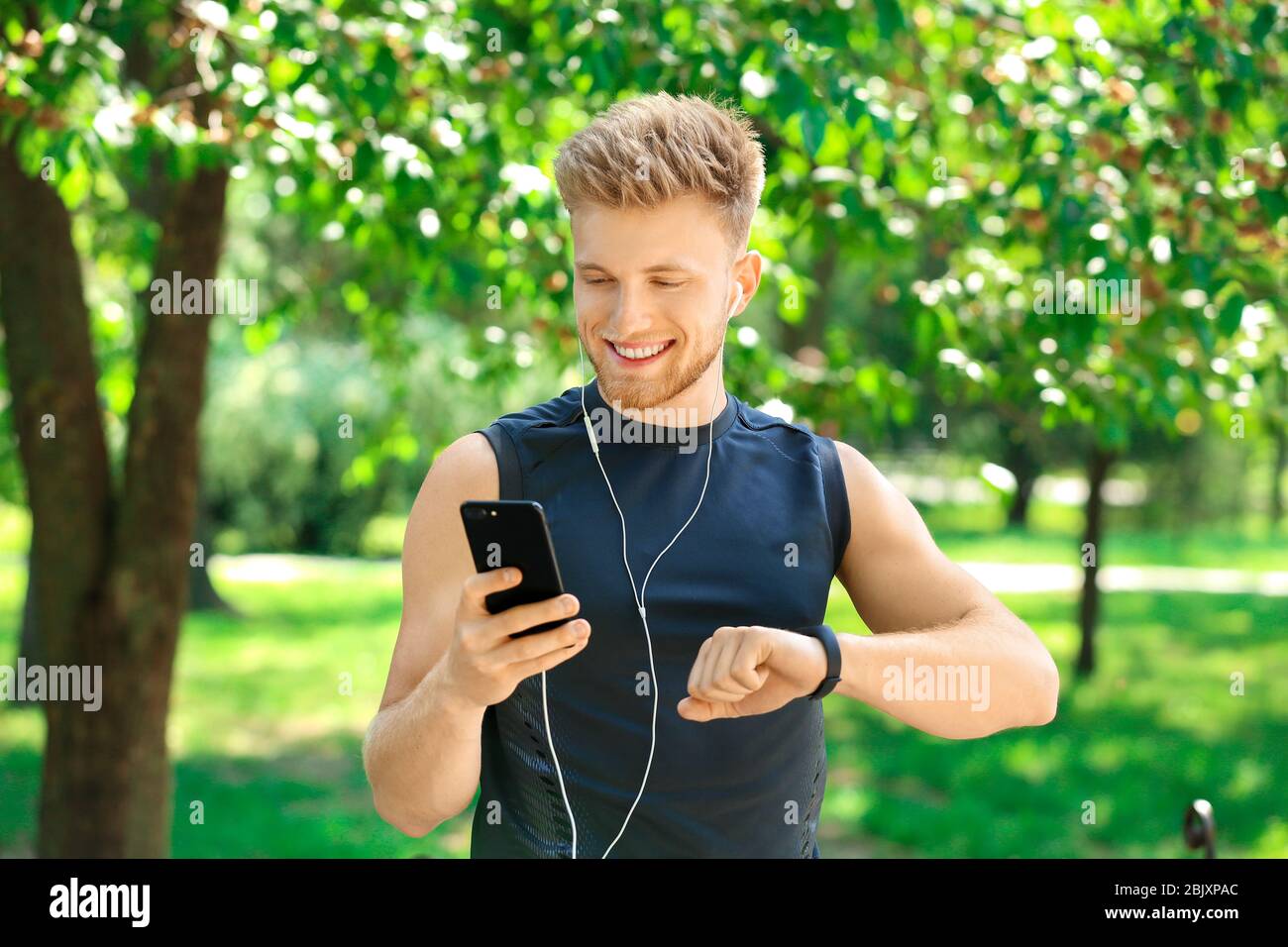 Sporty young man checking his pulse outdoors Stock Photo - Alamy