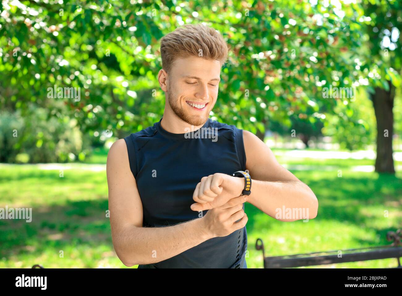 Sporty young man checking his pulse outdoors Stock Photo - Alamy