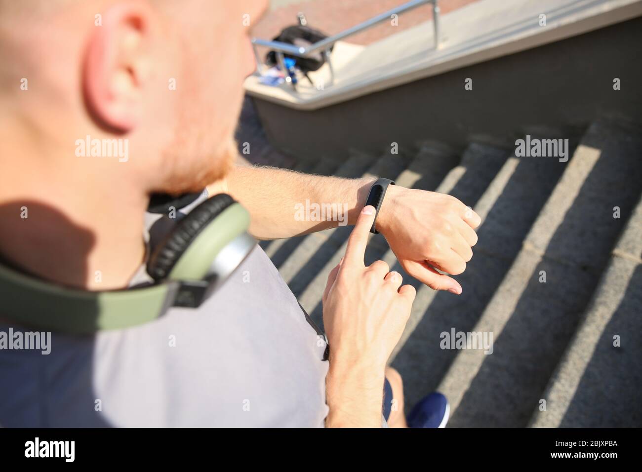 Sporty young man checking his pulse outdoors Stock Photo - Alamy