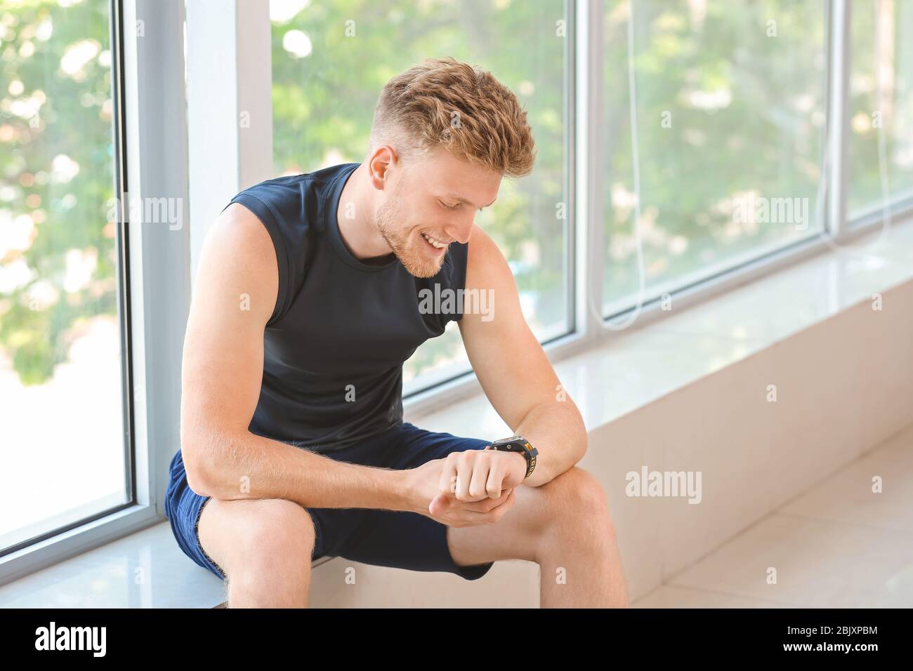 Sporty young man checking his pulse after training in gym Stock Photo ...