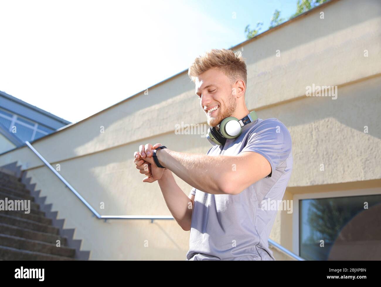 Sporty young man checking his pulse outdoors Stock Photo - Alamy