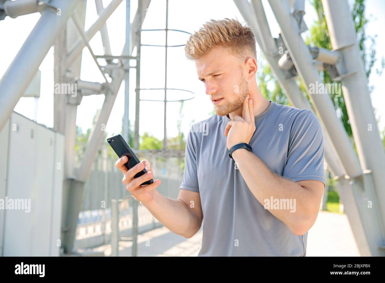 Sporty young man checking his pulse outdoors Stock Photo - Alamy