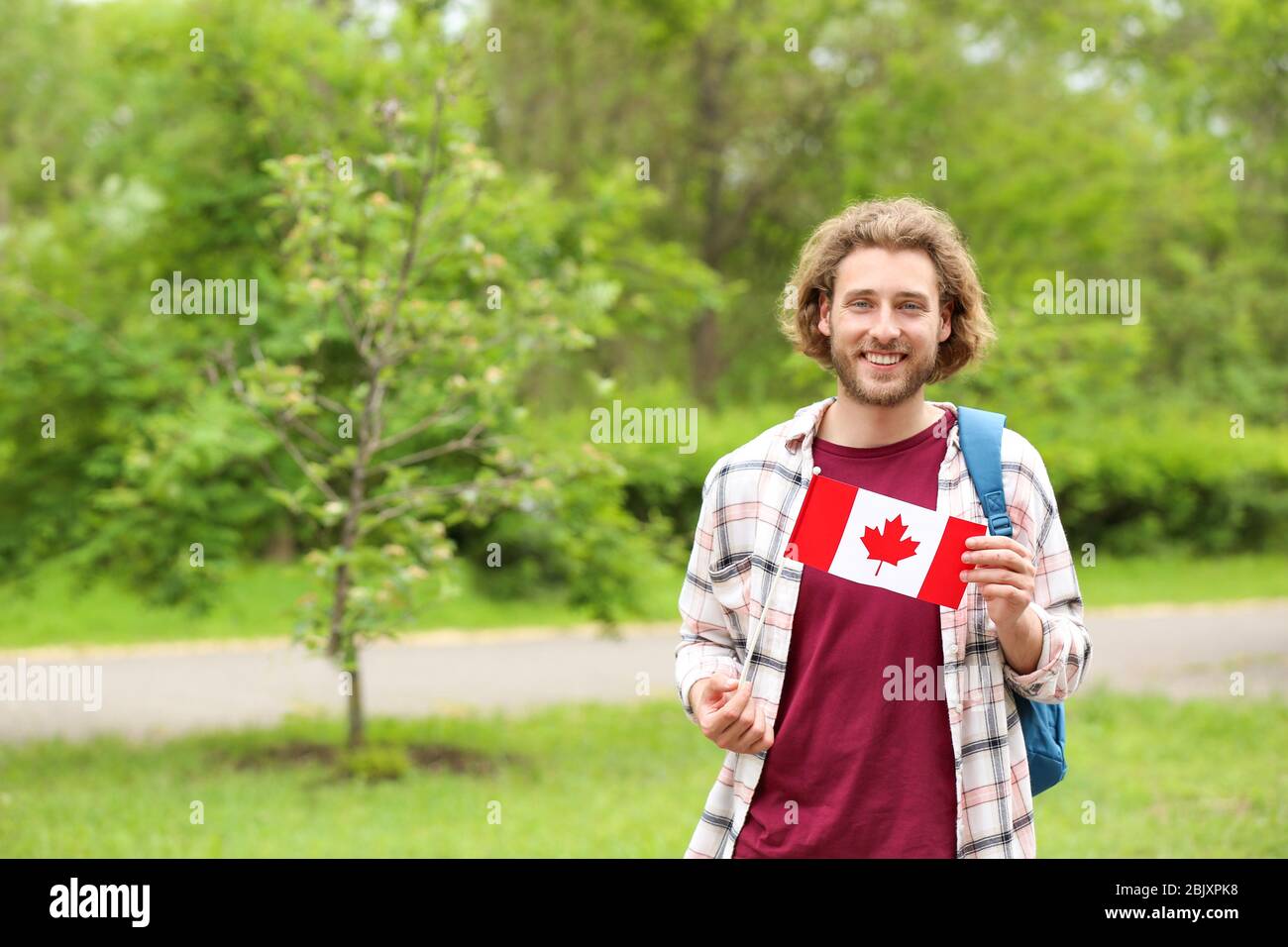 Male student with Canadian flag outdoors Stock Photo - Alamy