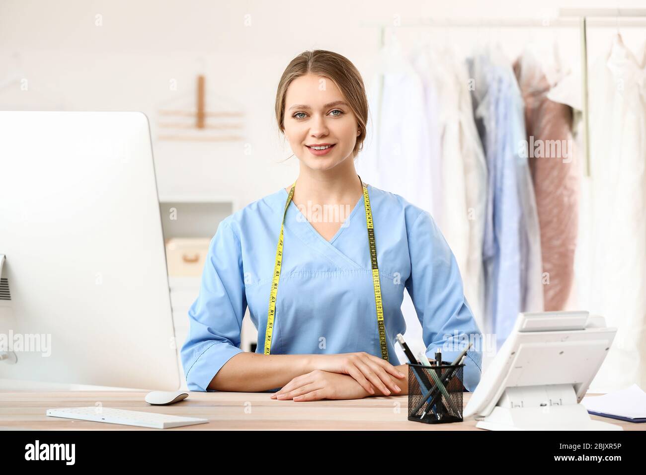 Worker of modern dry-cleaner's at reception Stock Photo - Alamy