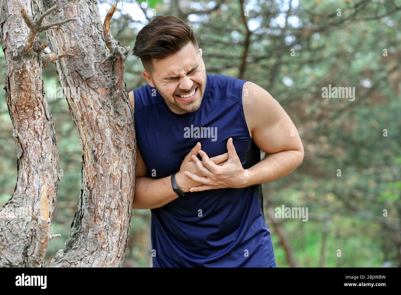 Sporty young man suffering from heart attack outdoors Stock Photo - Alamy