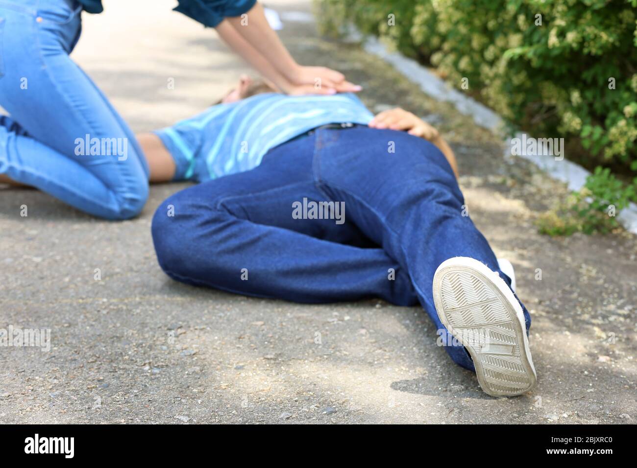 Woman giving CPR to unconscious man outdoors Stock Photo - Alamy