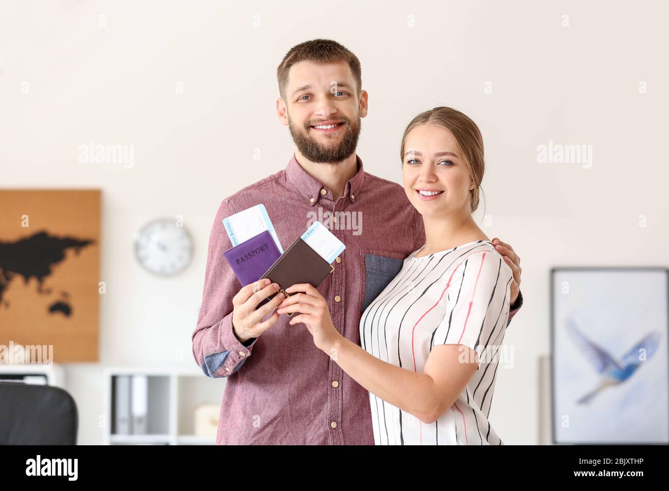 Happy couple with passports and tickets in travel agency Stock Photo ...