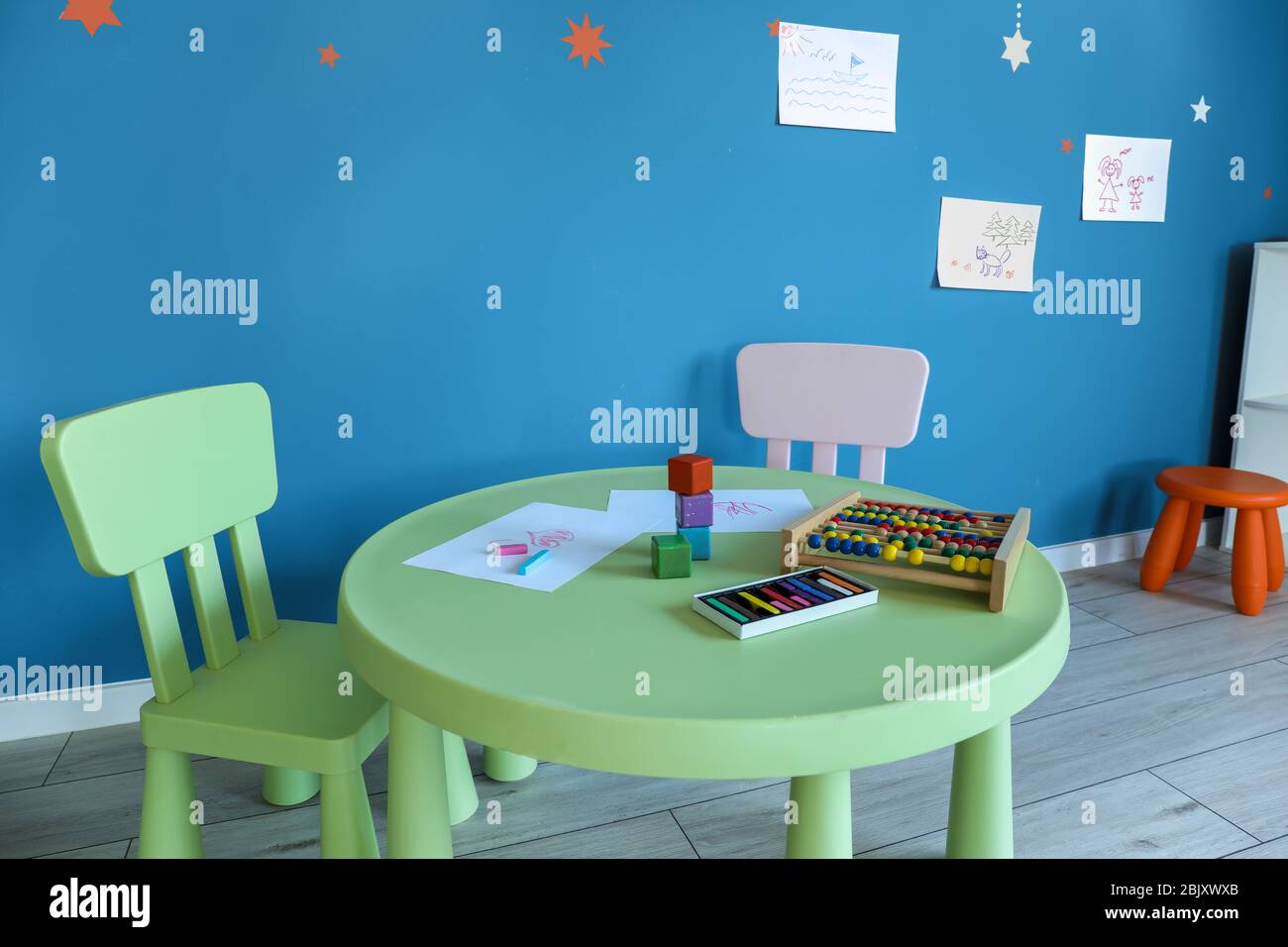 Table with abacus and kid's drawing in kindergarten Stock Photo - Alamy