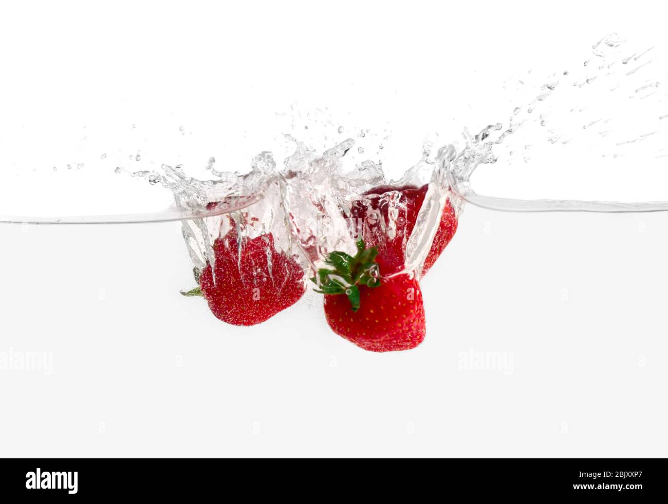 Falling of sweet strawberry in water against white background Stock ...