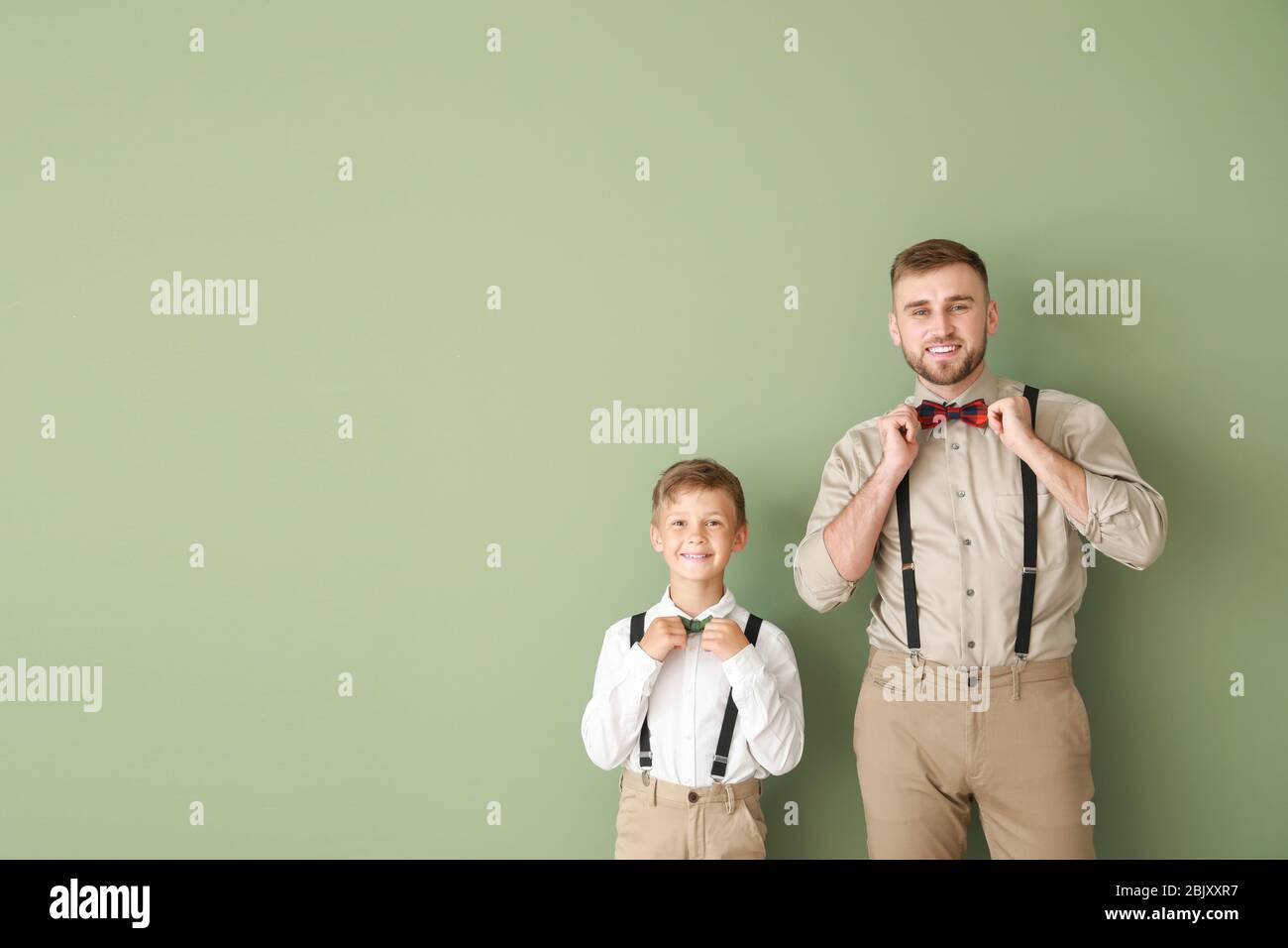 Portrait of fashionable father and son on color background Stock Photo ...