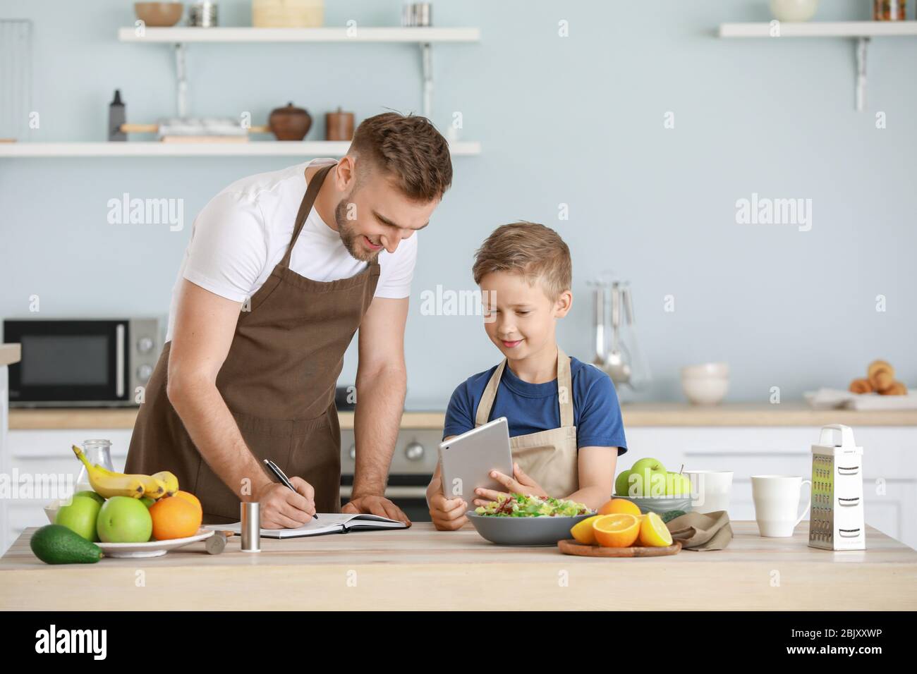 Portrait of happy father and son cooking in kitchen Stock Photo - Alamy