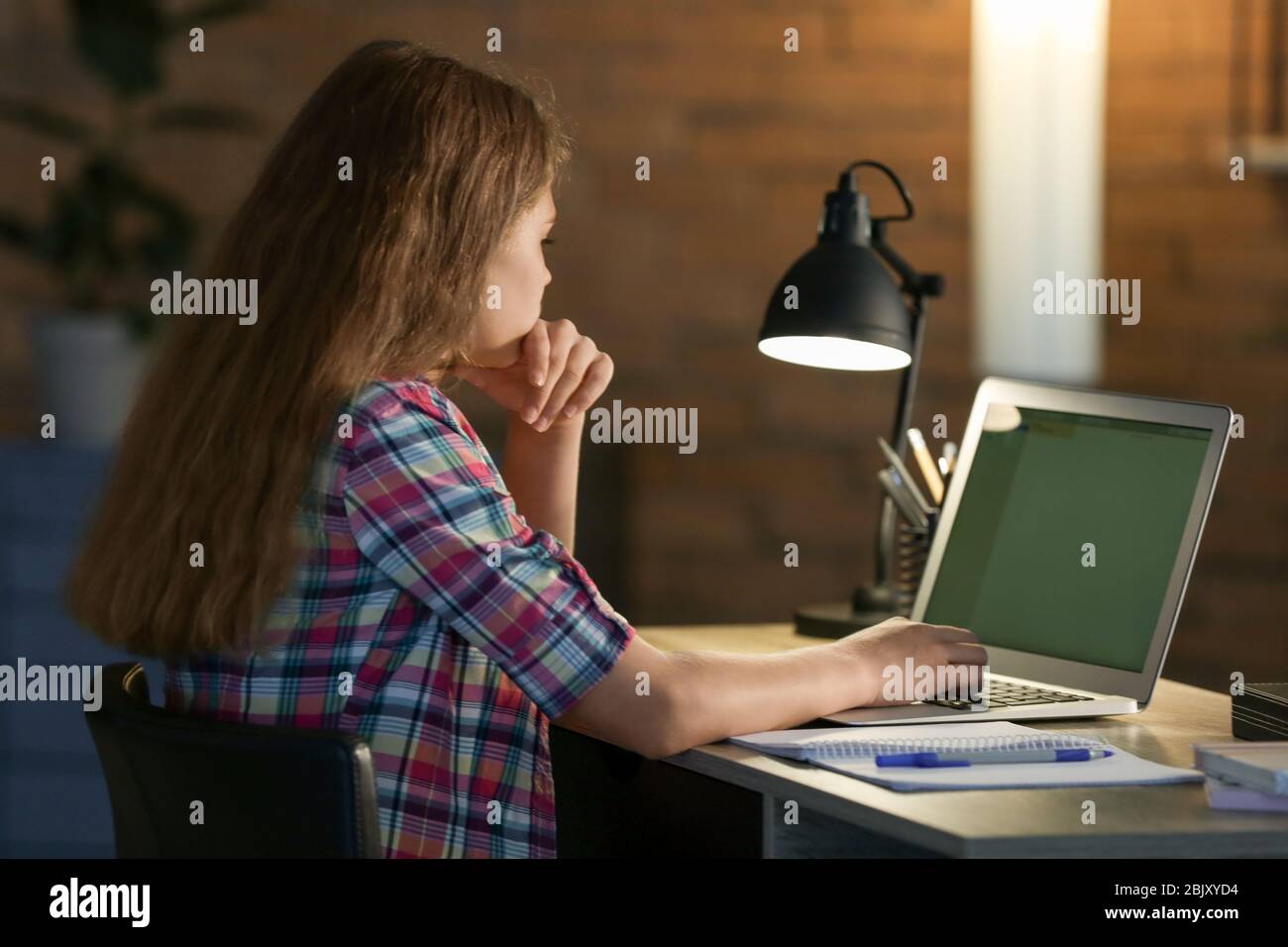 Teenage girl doing homework late in evening Stock Photo - Alamy