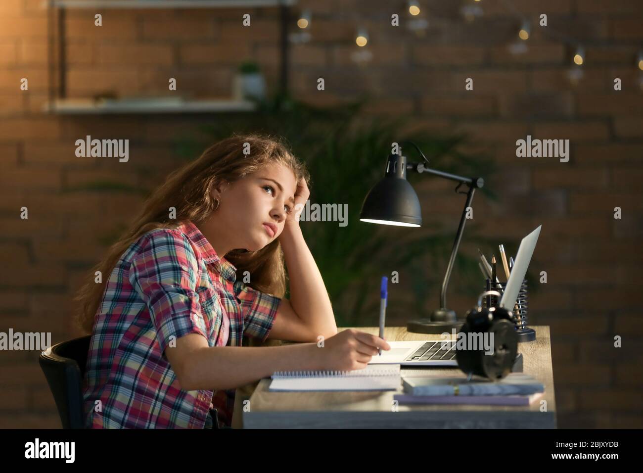 Tired teenage girl doing homework late in evening Stock Photo - Alamy