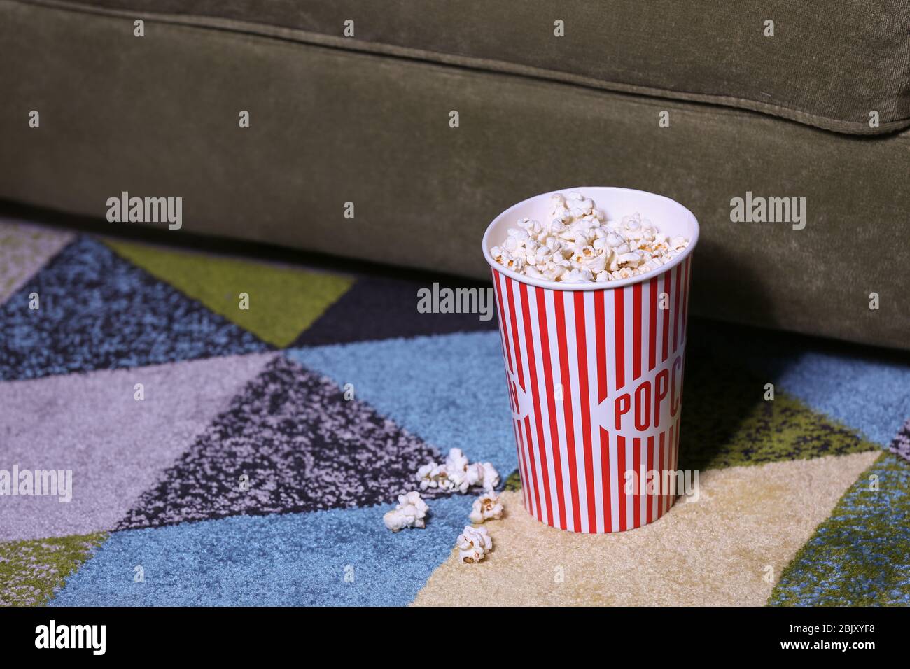 Bucket with popcorn on floor in room Stock Photo - Alamy