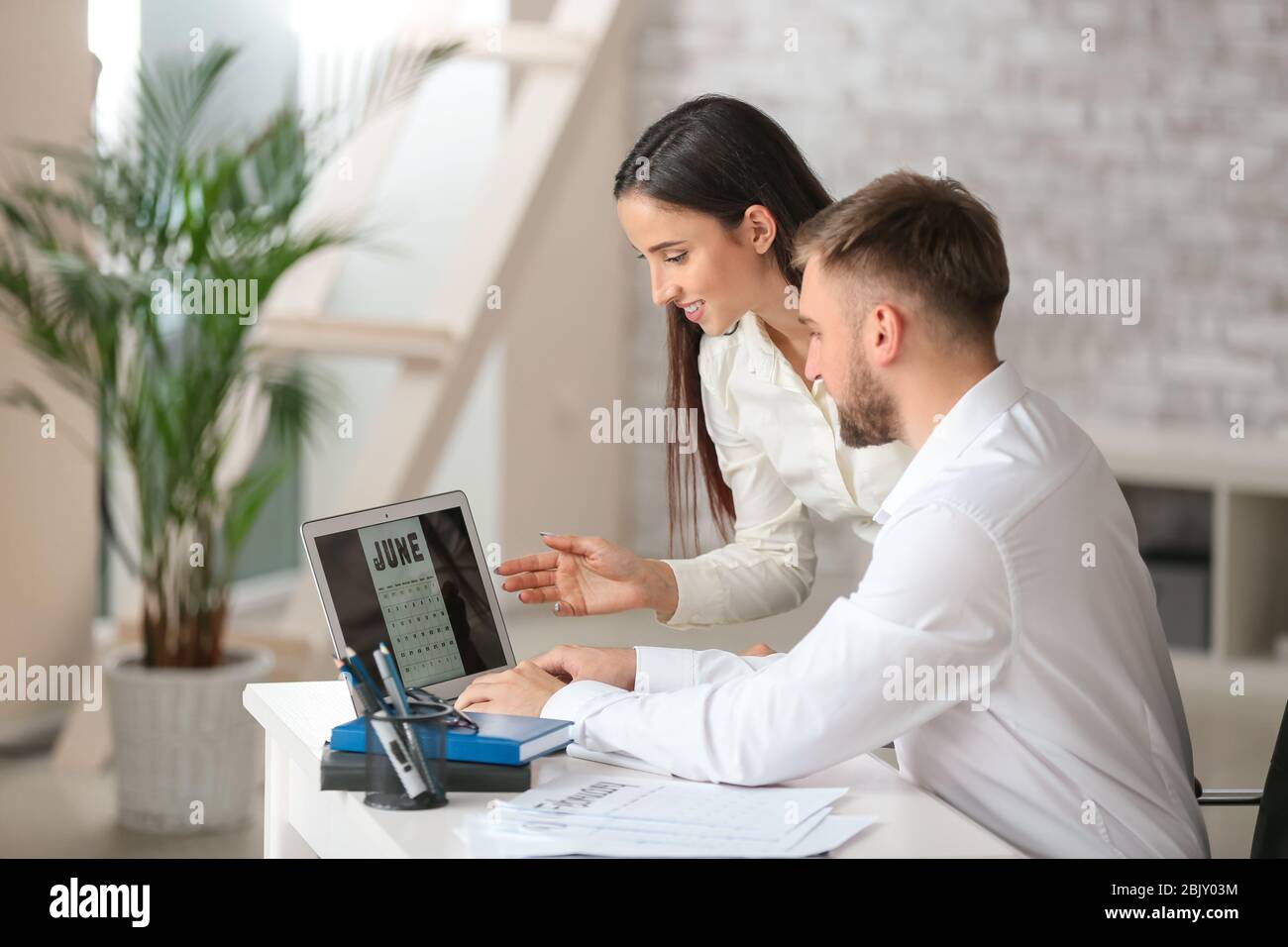 Office workers using calendar on laptop screen during work Stock Photo ...