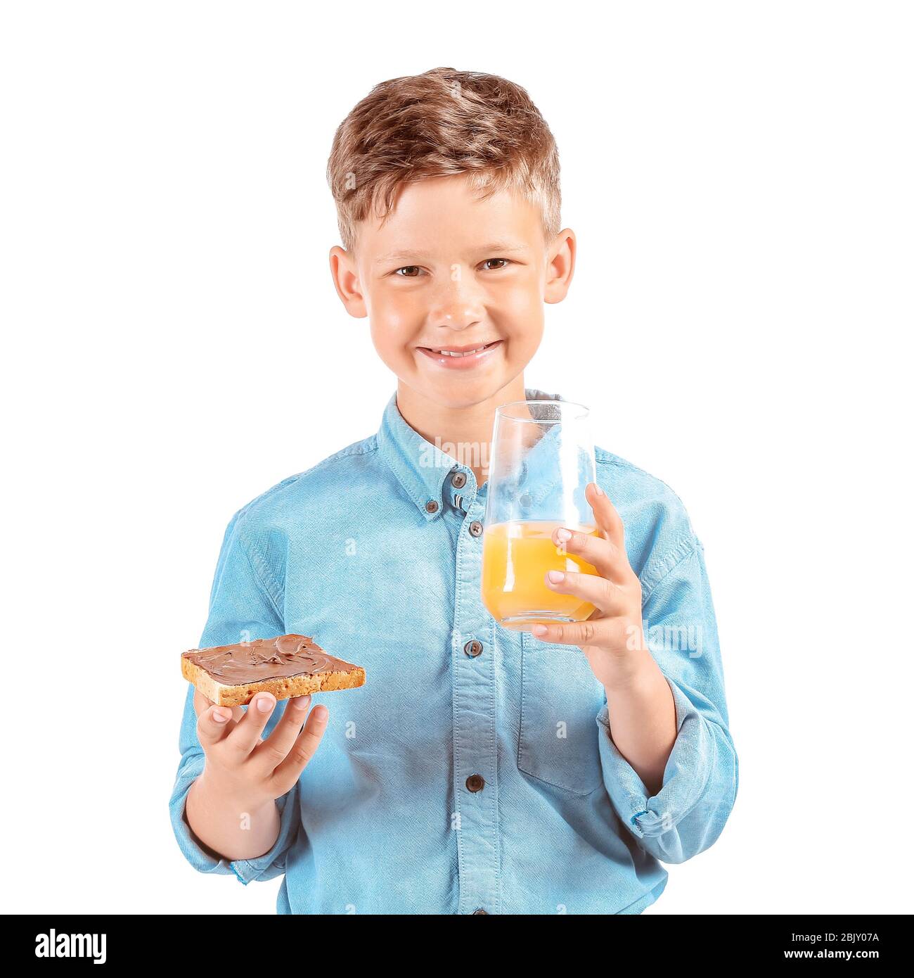Funny little boy with tasty toast and glass of juice on white ...
