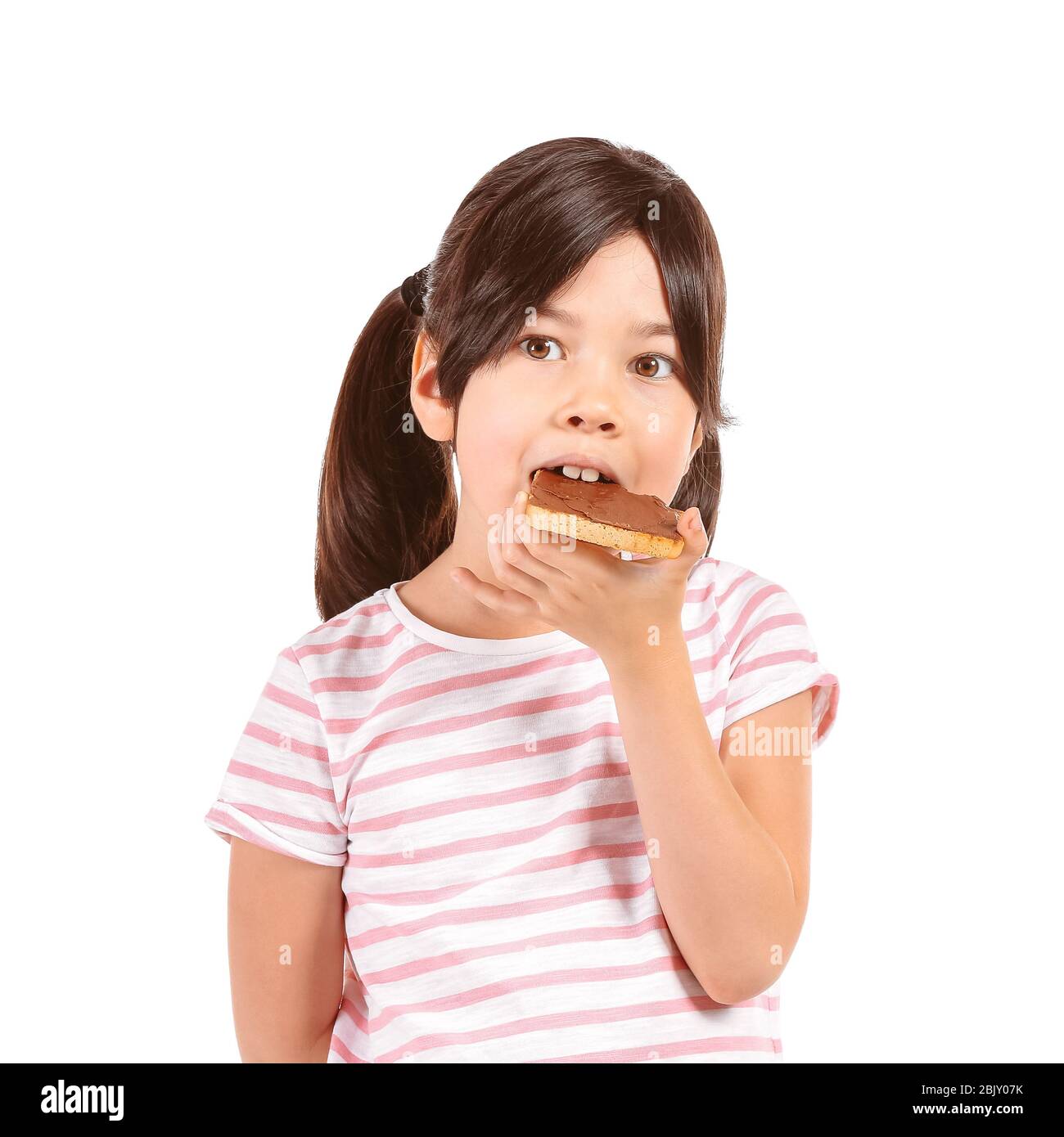 Funny little girl eating tasty toast on white background Stock Photo ...