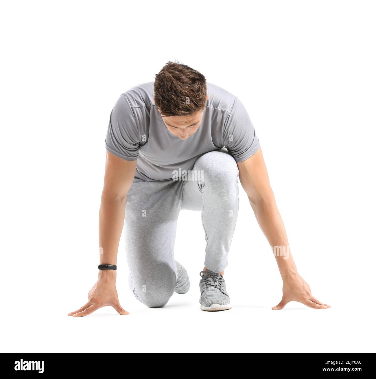 Sporty young man in crouch start position on white background Stock ...