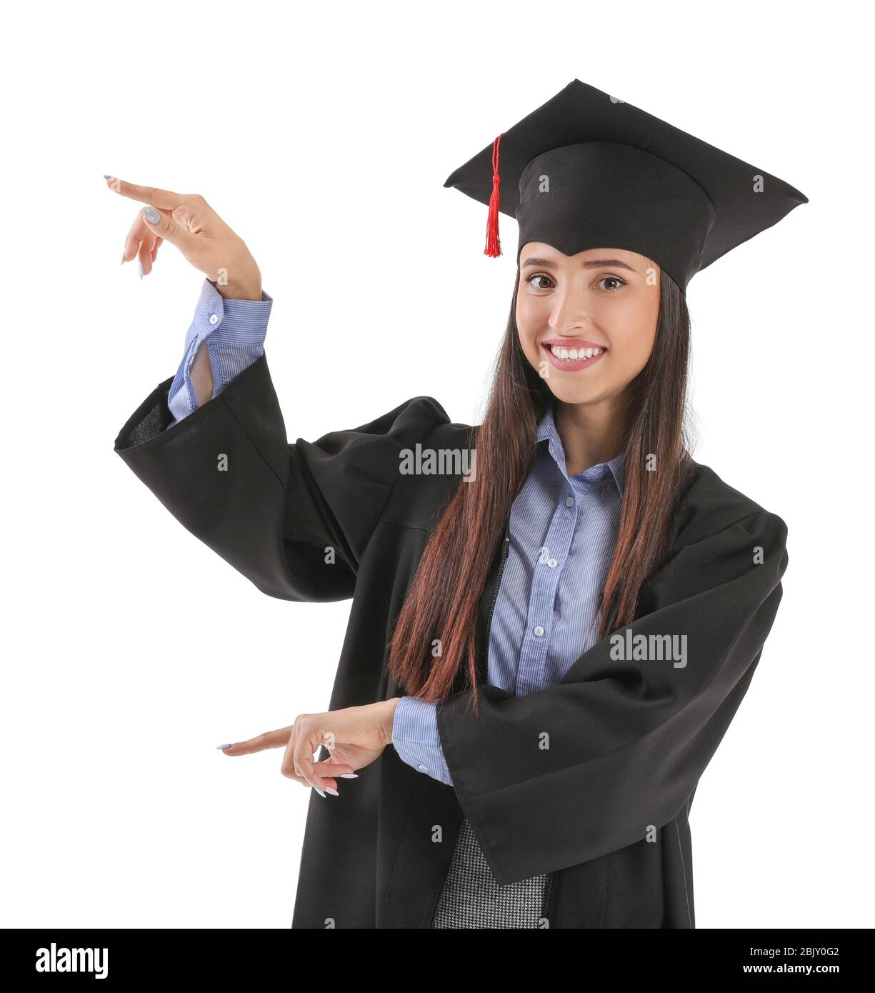 Female student in graduation cap and gown pointing at something on ...