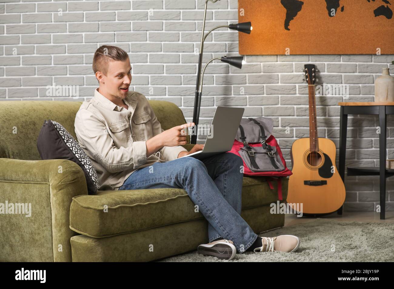 Male travel blogger with laptop at home Stock Photo - Alamy