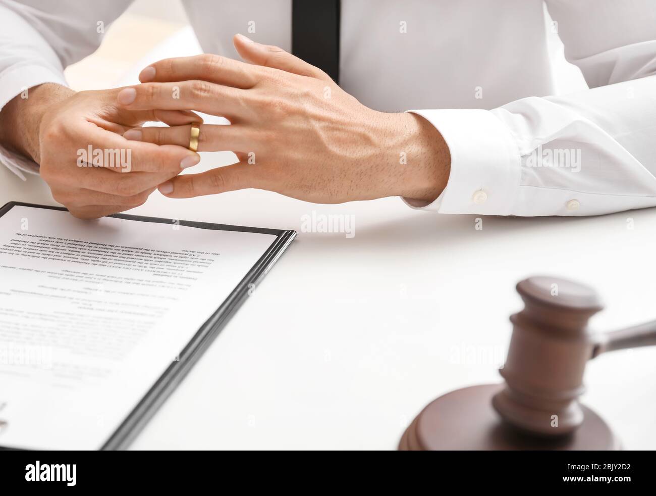 Man taking wedding ring off his finger at lawyer's office. Concept of ...