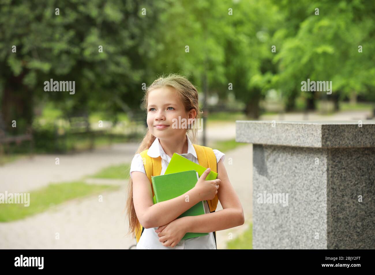 Cute little schoolgirl in park Stock Photo - Alamy