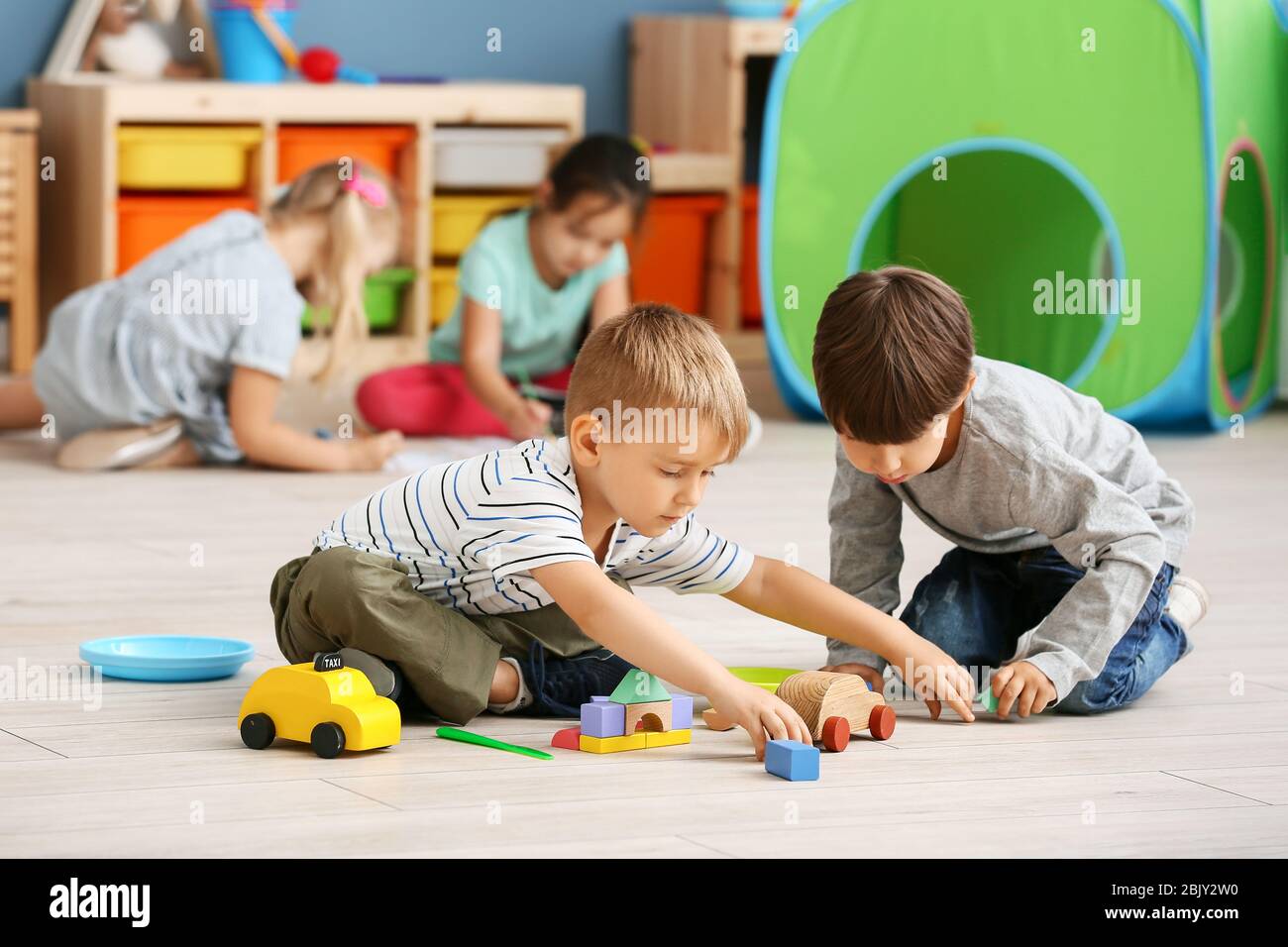 Cute little children playing in kindergarten Stock Photo - Alamy