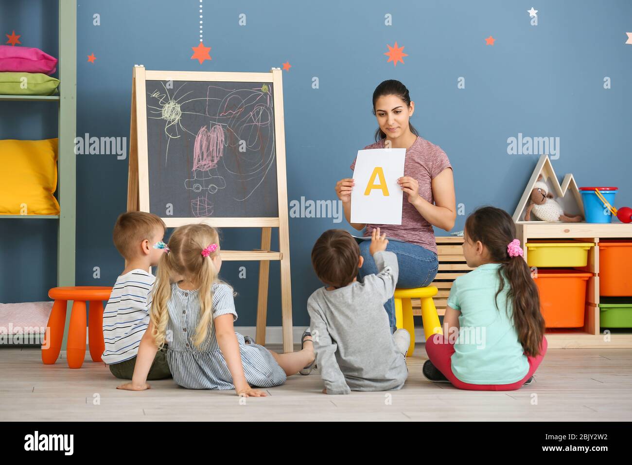 Cute little children learning letters in kindergarten Stock Photo - Alamy