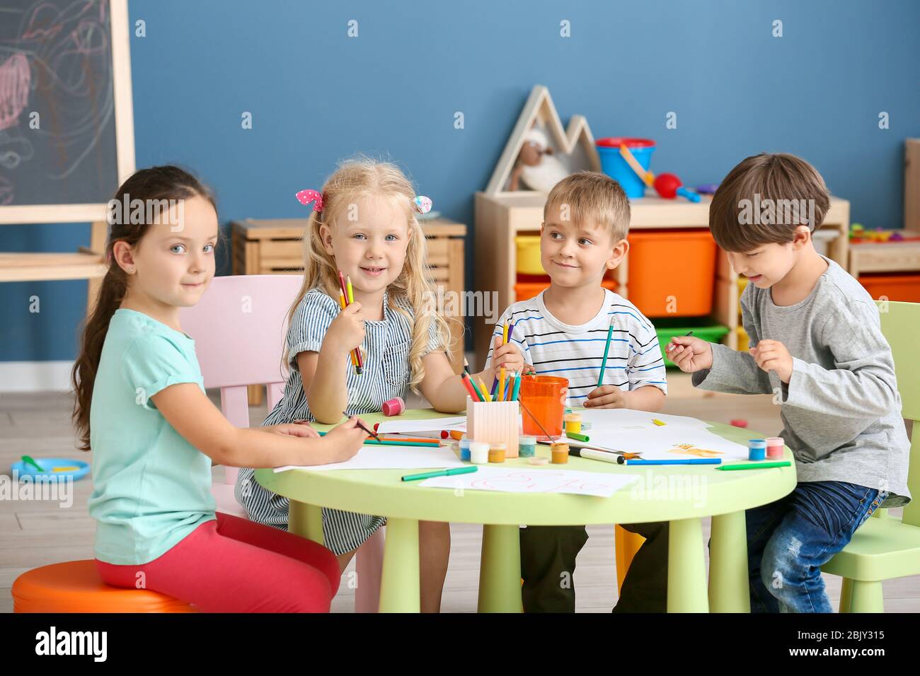 Cute little children drawing in kindergarten Stock Photo - Alamy