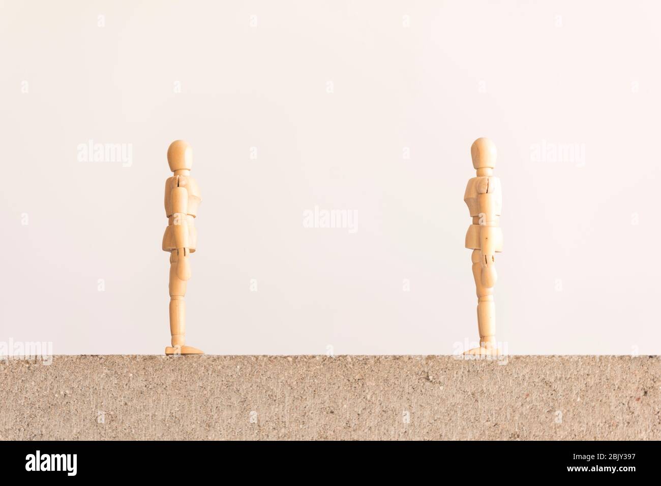 Social distancing symbol: two wooden human figures standing on a ...