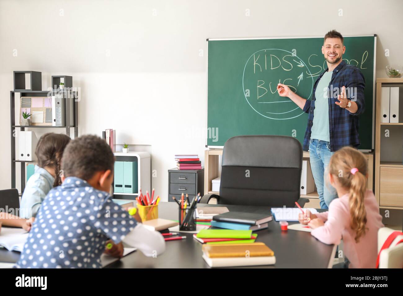 Teacher conducting lesson in classroom Stock Photo - Alamy