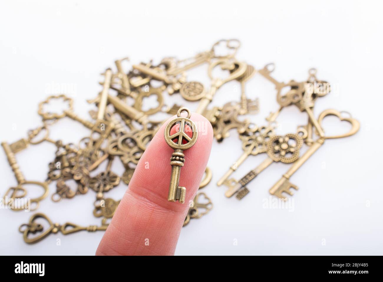 Peace symbol key in hand over and retro style metal keys Stock Photo ...
