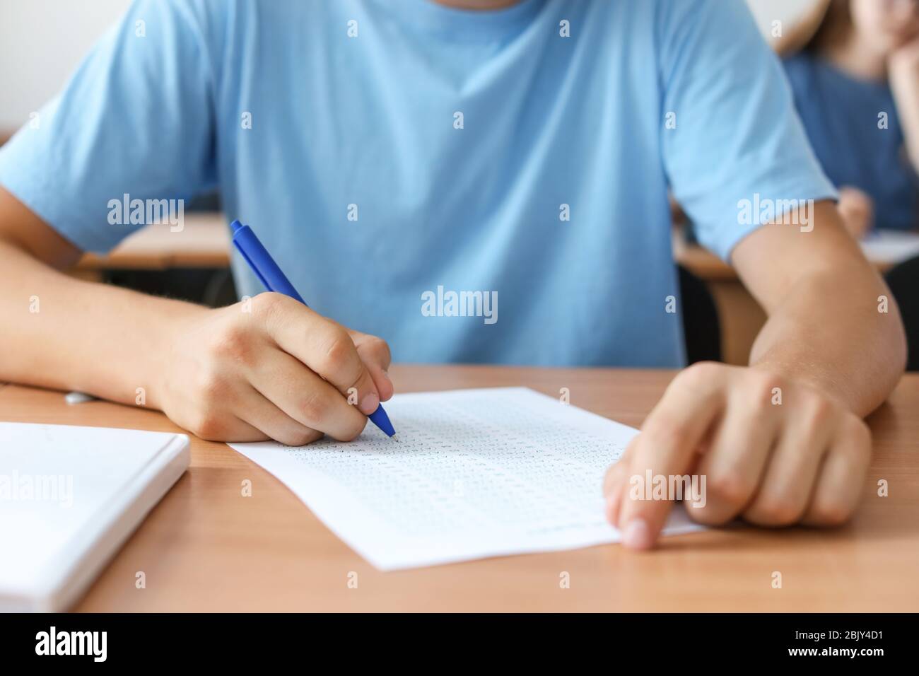 Teenage boy passing school test in classroom Stock Photo - Alamy
