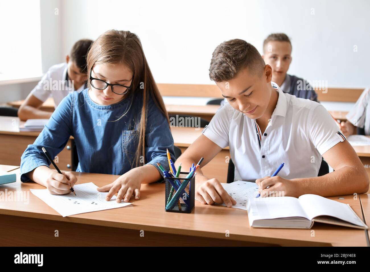 Pupils passing school test in classroom Stock Photo - Alamy