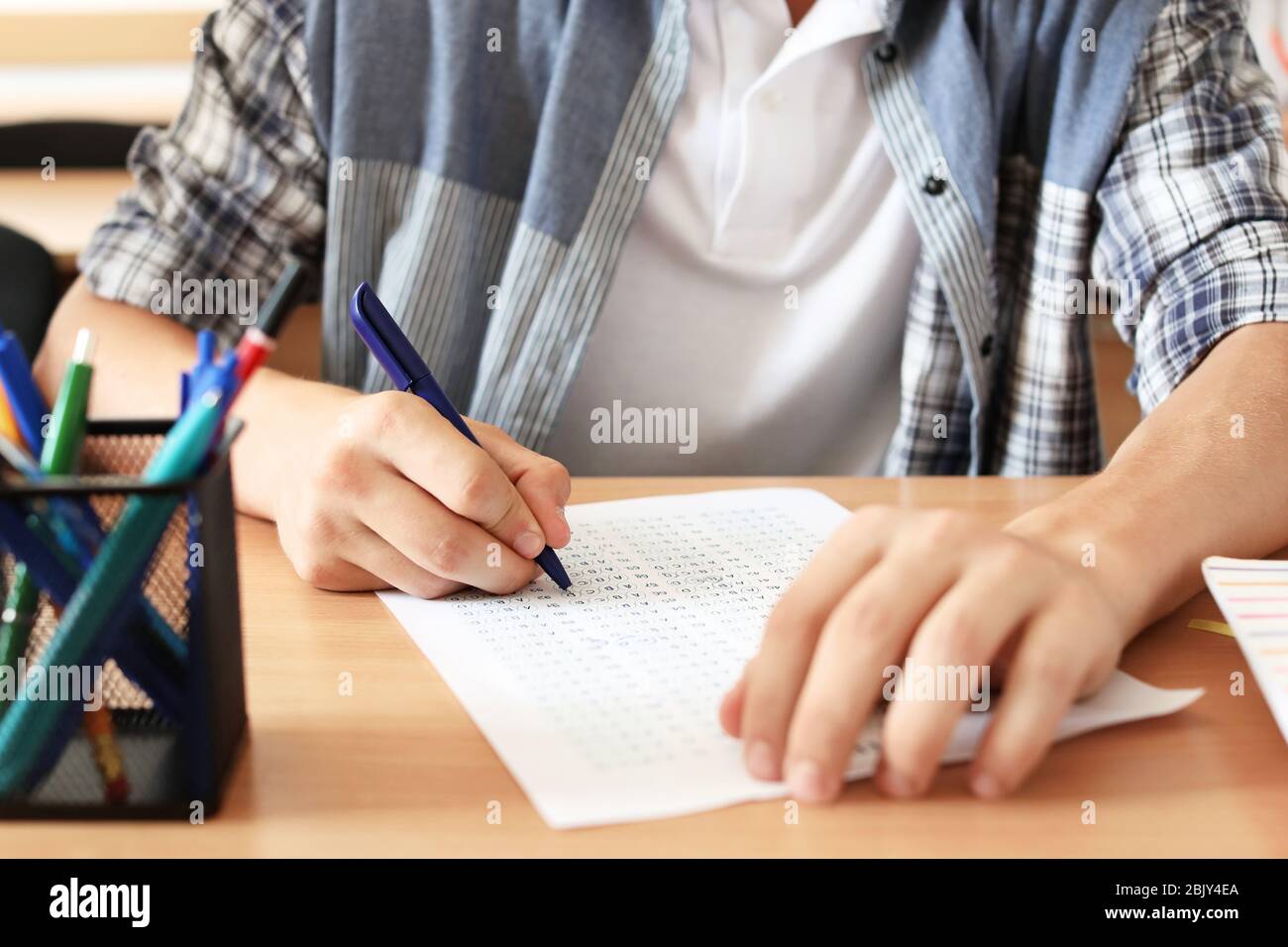 Teenage boy passing school test in classroom Stock Photo - Alamy