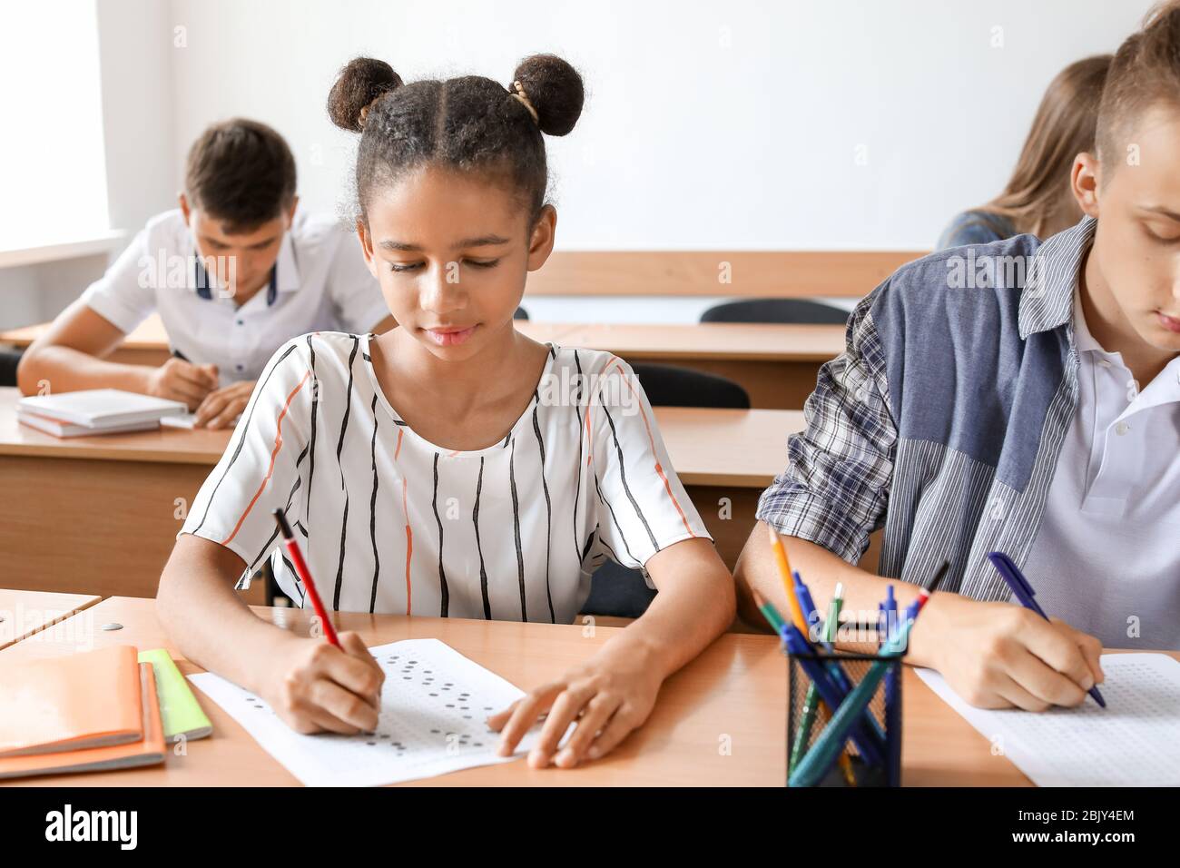 Pupils passing school test in classroom Stock Photo - Alamy