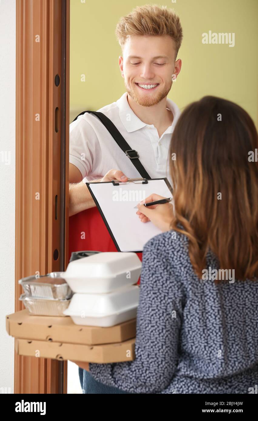 Woman signing documents to confirm receiving of order from food ...