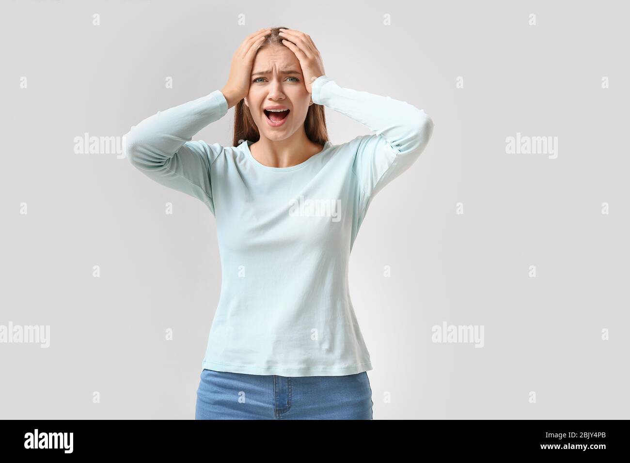 Woman having panic attack on light background Stock Photo - Alamy