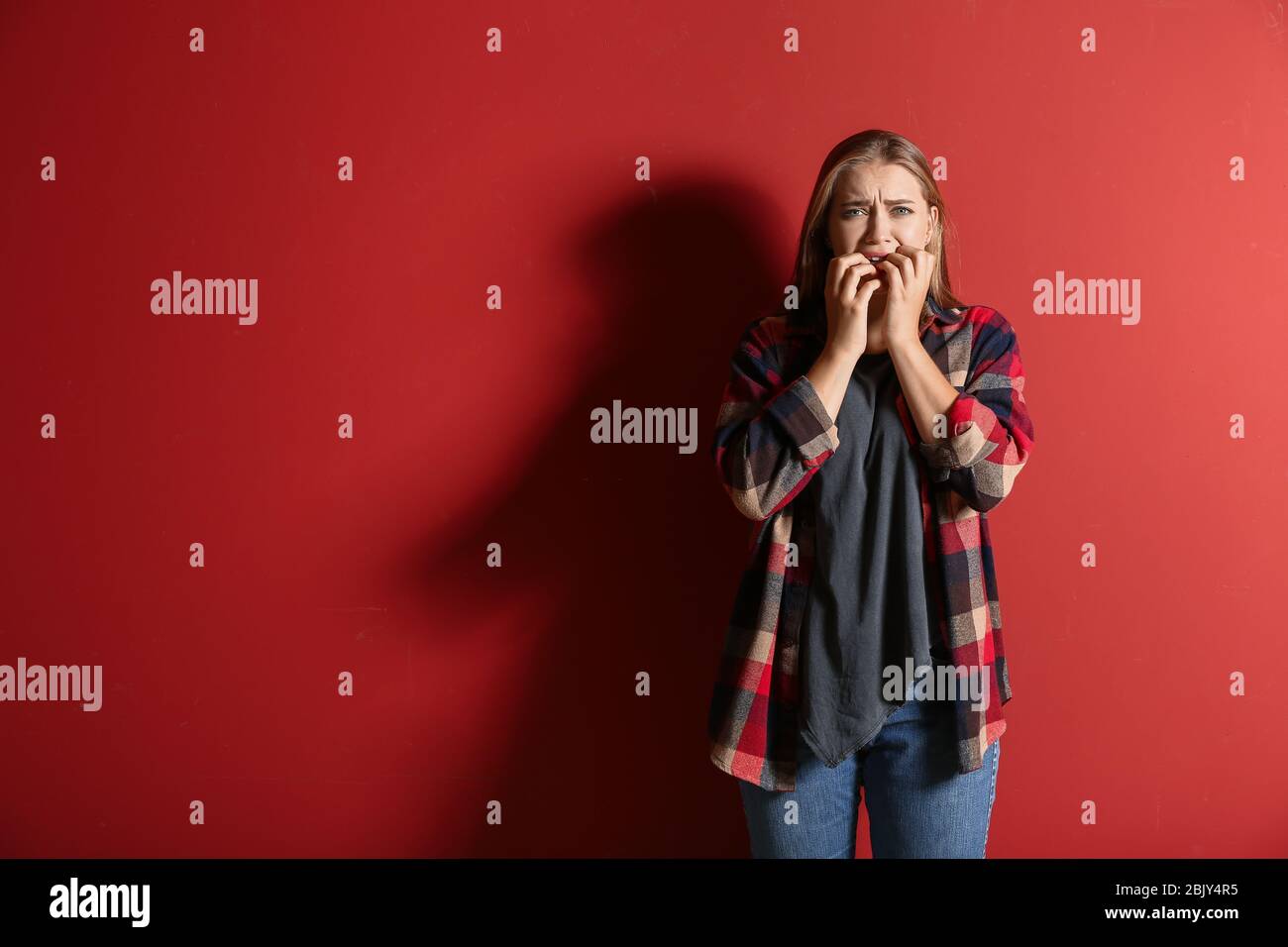 Woman having panic attack on color background Stock Photo - Alamy