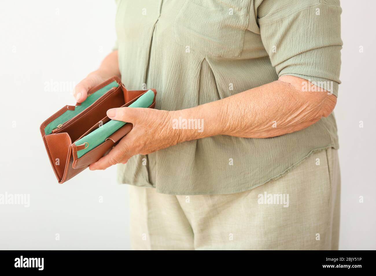 Elderly woman with empty wallet on white background, closeup. Concept ...