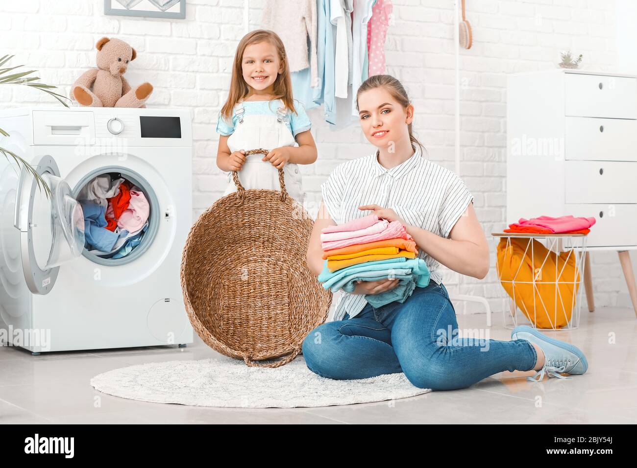 Woman and her little daughter doing laundry at home Stock Photo - Alamy