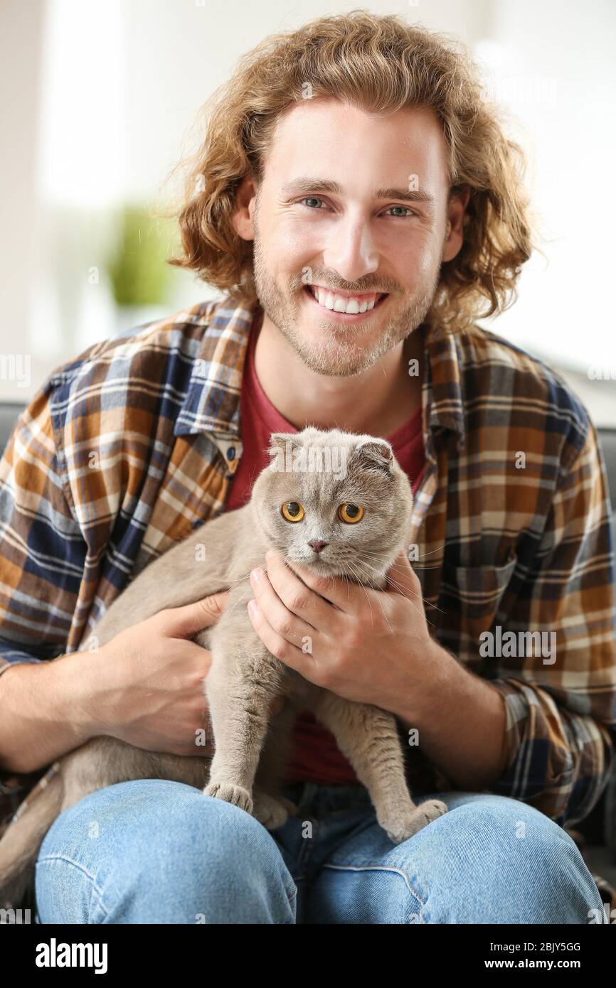 Man with cute funny cat at home Stock Photo - Alamy
