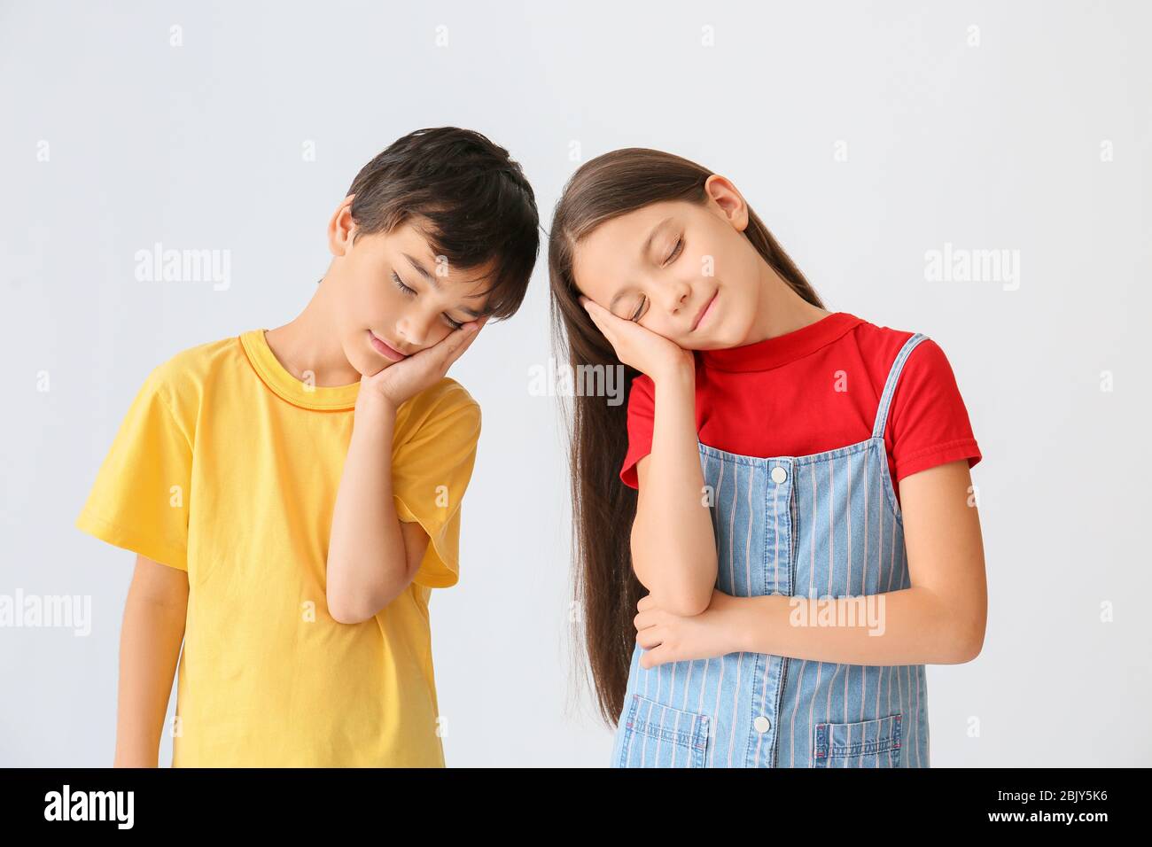 Portrait of sleepy children on light background Stock Photo - Alamy