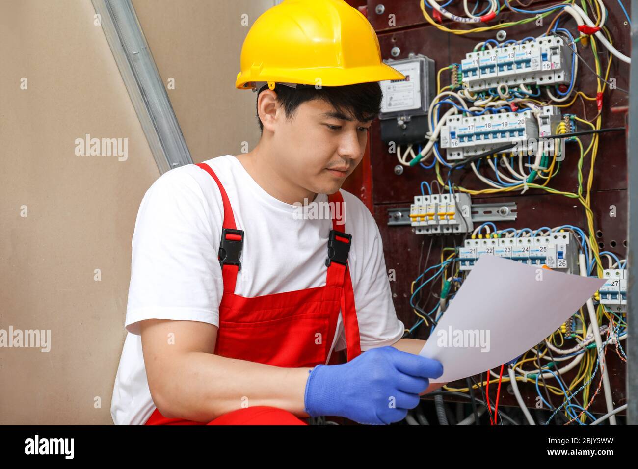 Electrician with wiring diagram indoors Stock Photo - Alamy