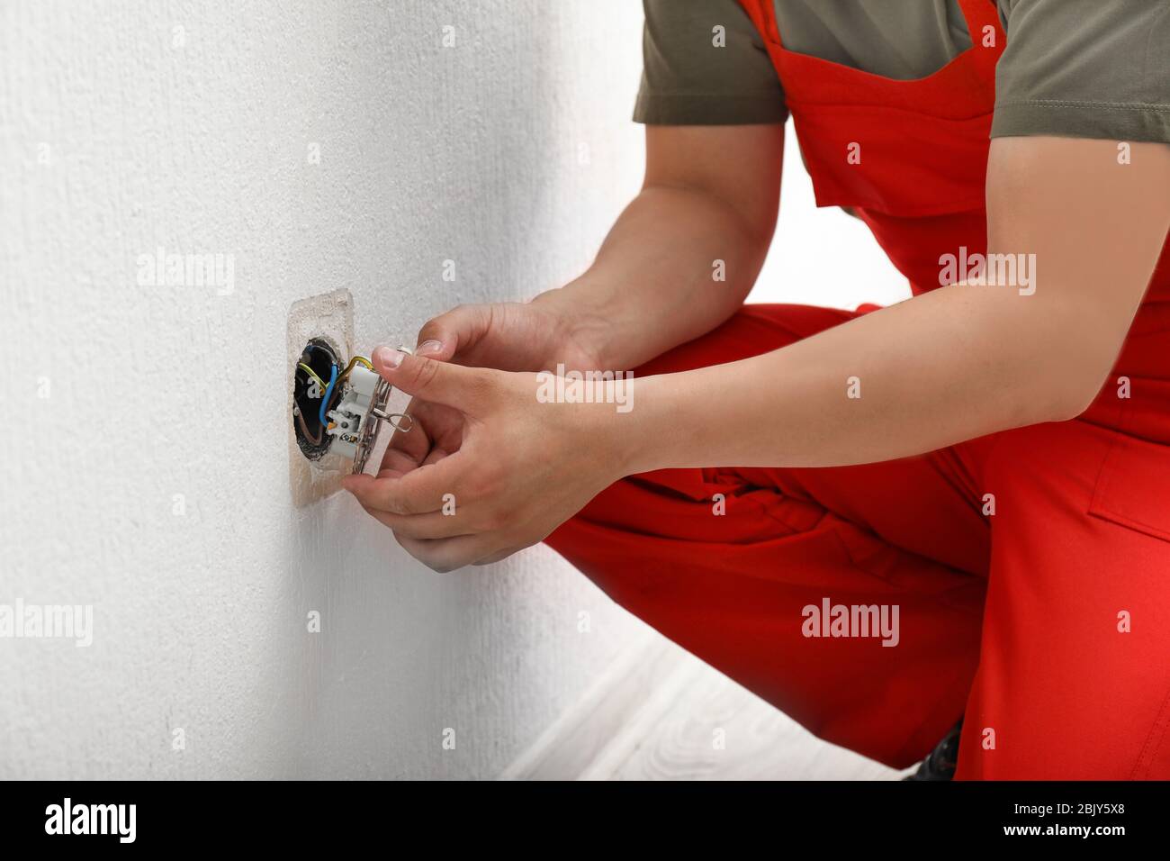 Electrician repairing socket in room Stock Photo - Alamy