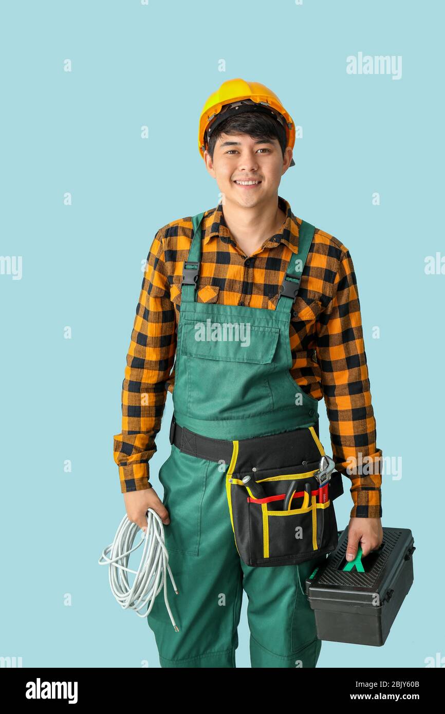 Male electrician on color background Stock Photo - Alamy