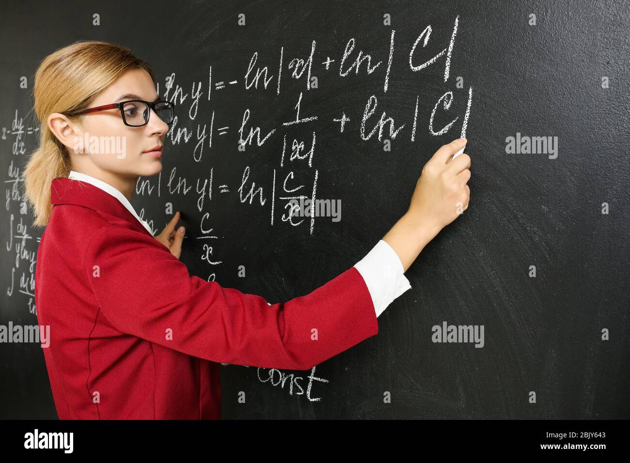 Beautiful math teacher near blackboard in classroom Stock Photo - Alamy