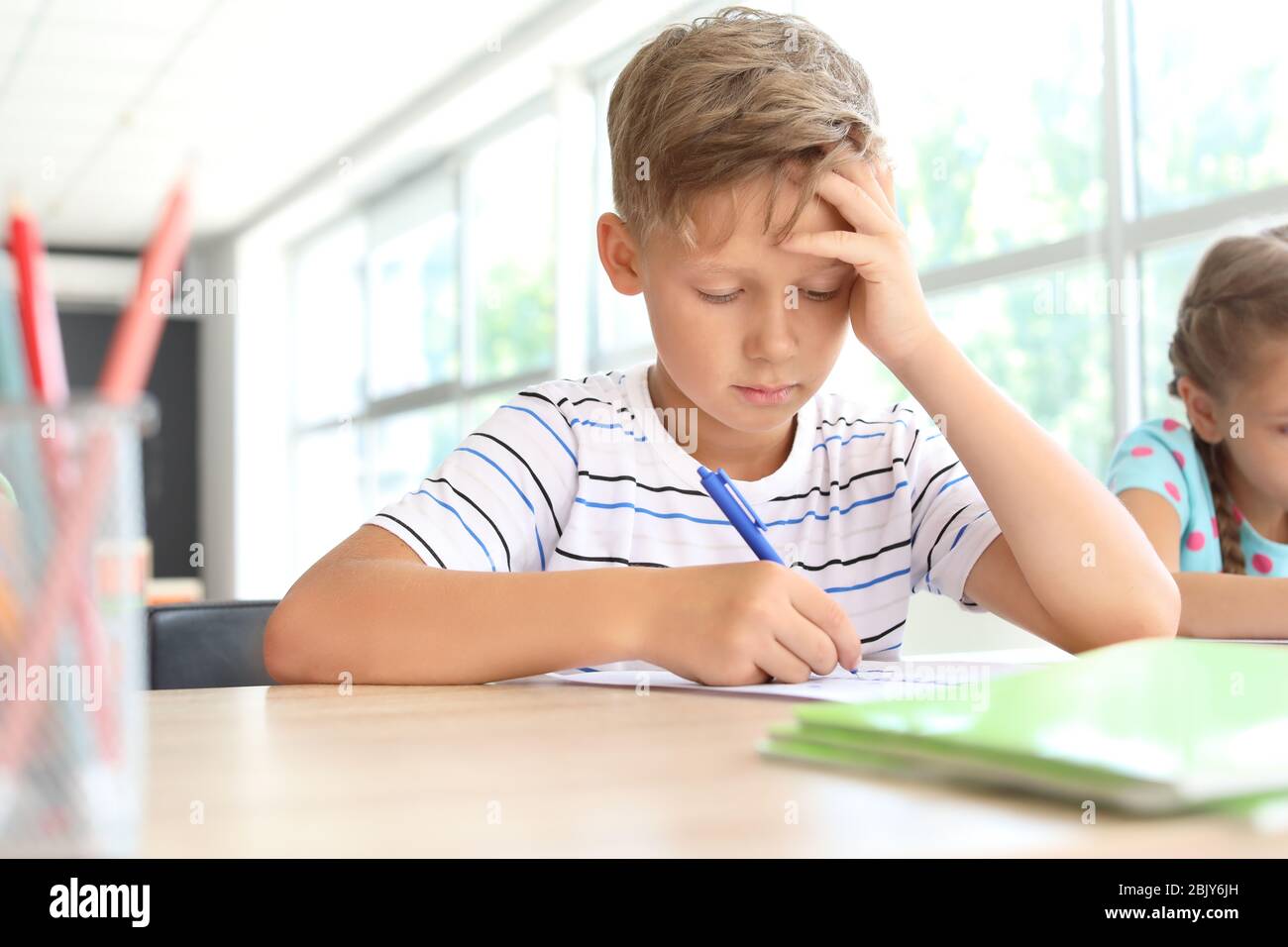 Boy passing difficult school test in classroom Stock Photo - Alamy